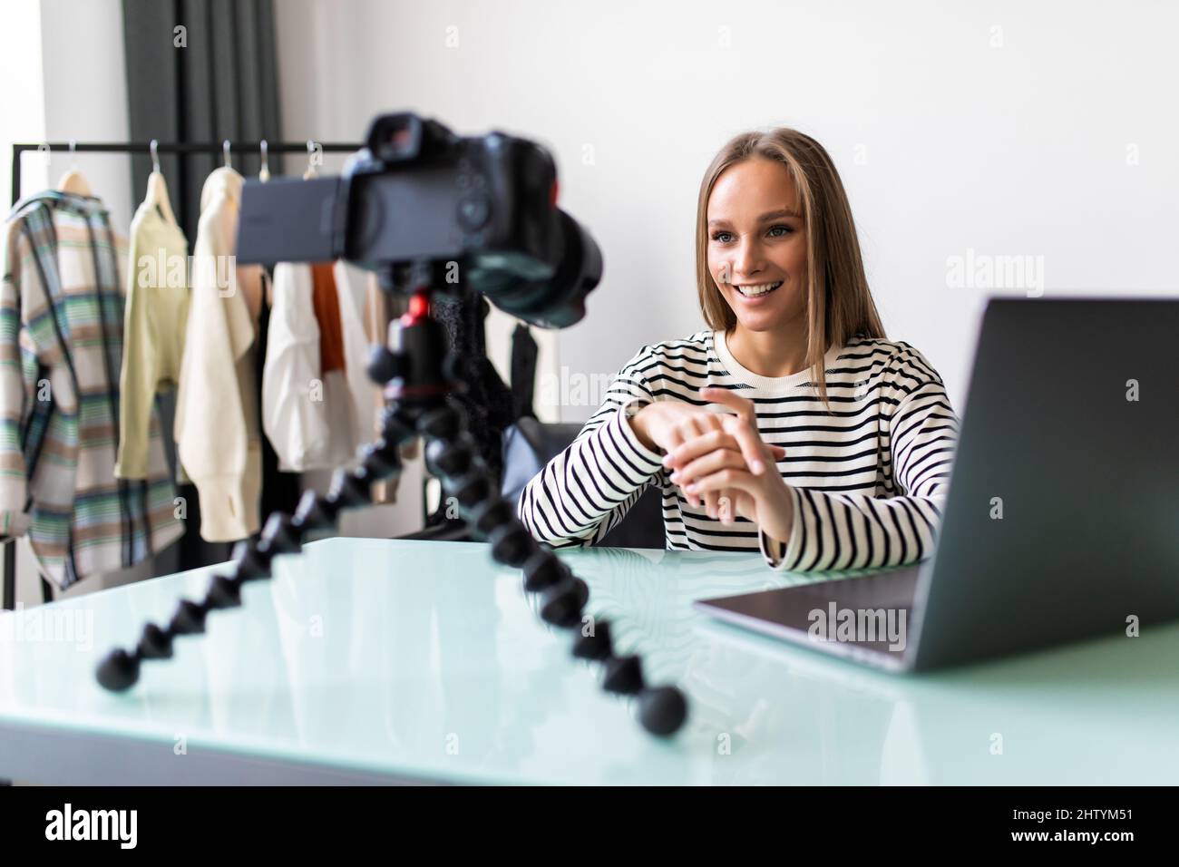 Confident young female vlogger sit at desk shooting live broadcast on ...