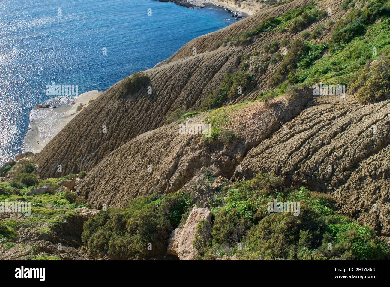 Steep blue clay slopes, with flaking debris forming scree on limestone ...