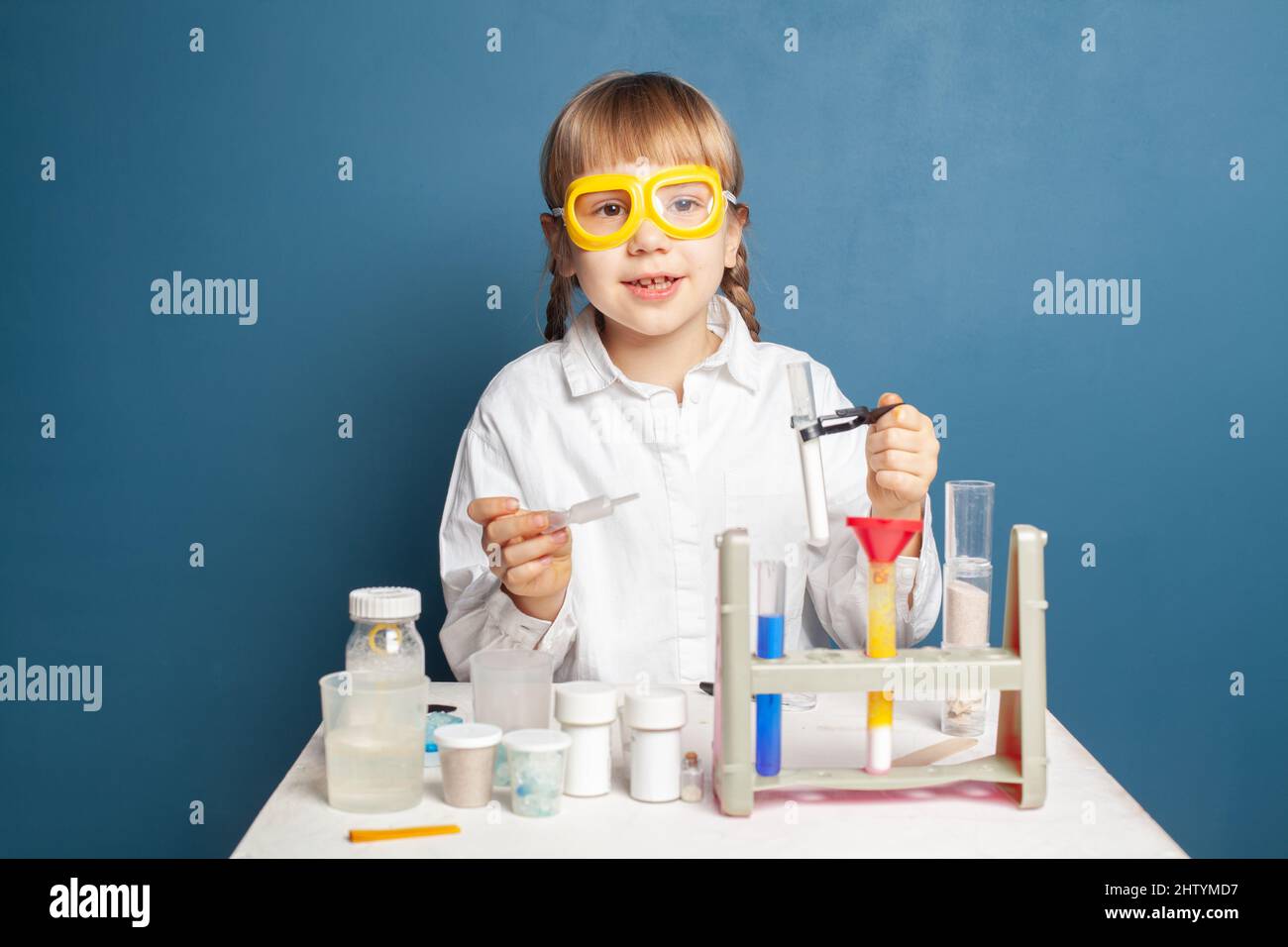 Happy child girl holding flask in science class Stock Photo - Alamy