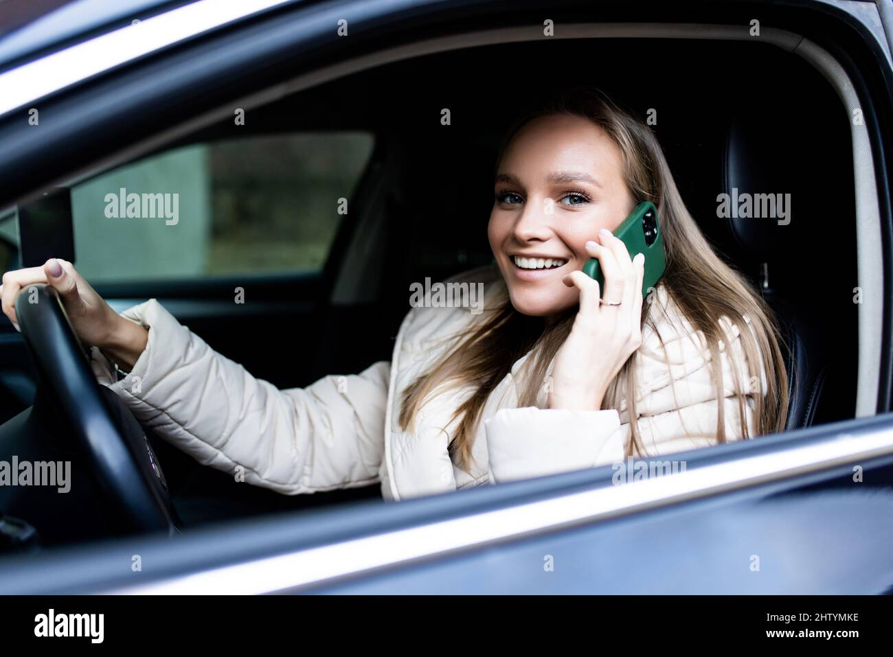 businesswoman driving car and talking on cell phone concentrating on ...