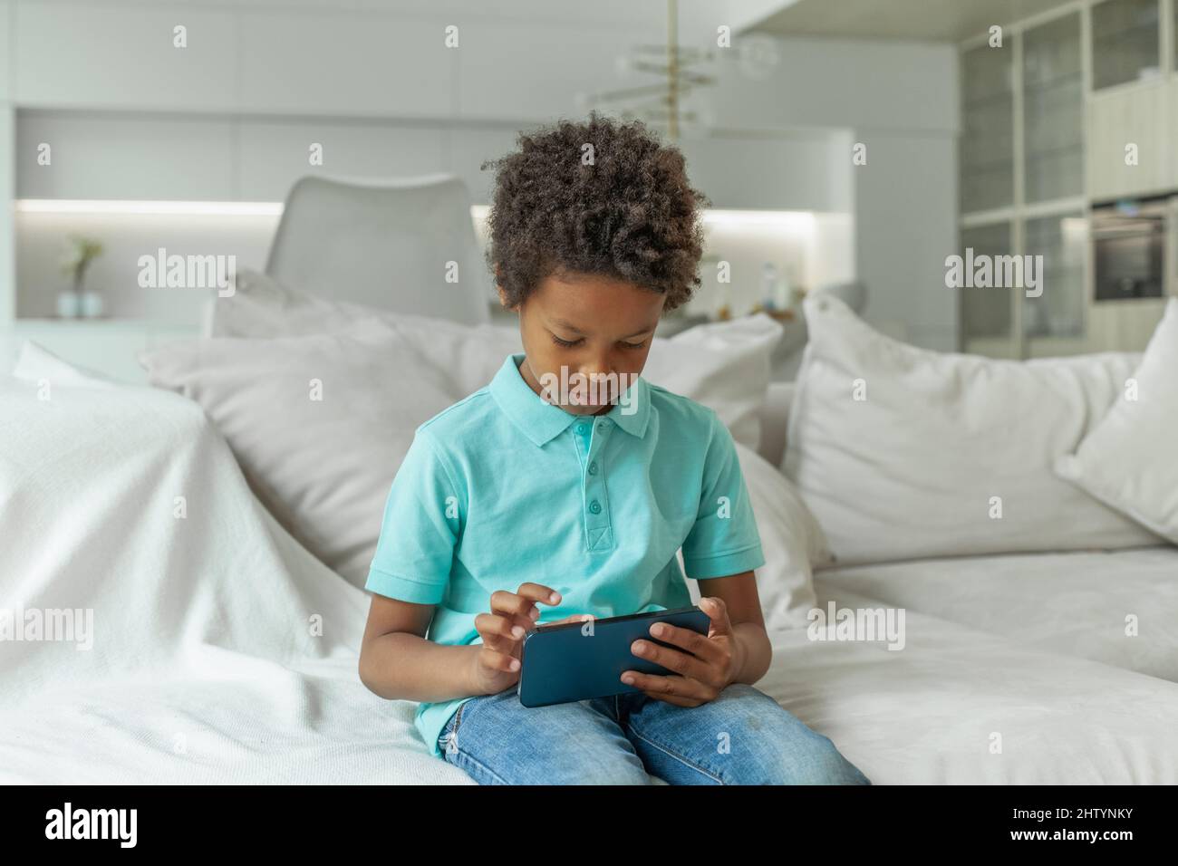 Little boy using mobile phone at home Stock Photo - Alamy