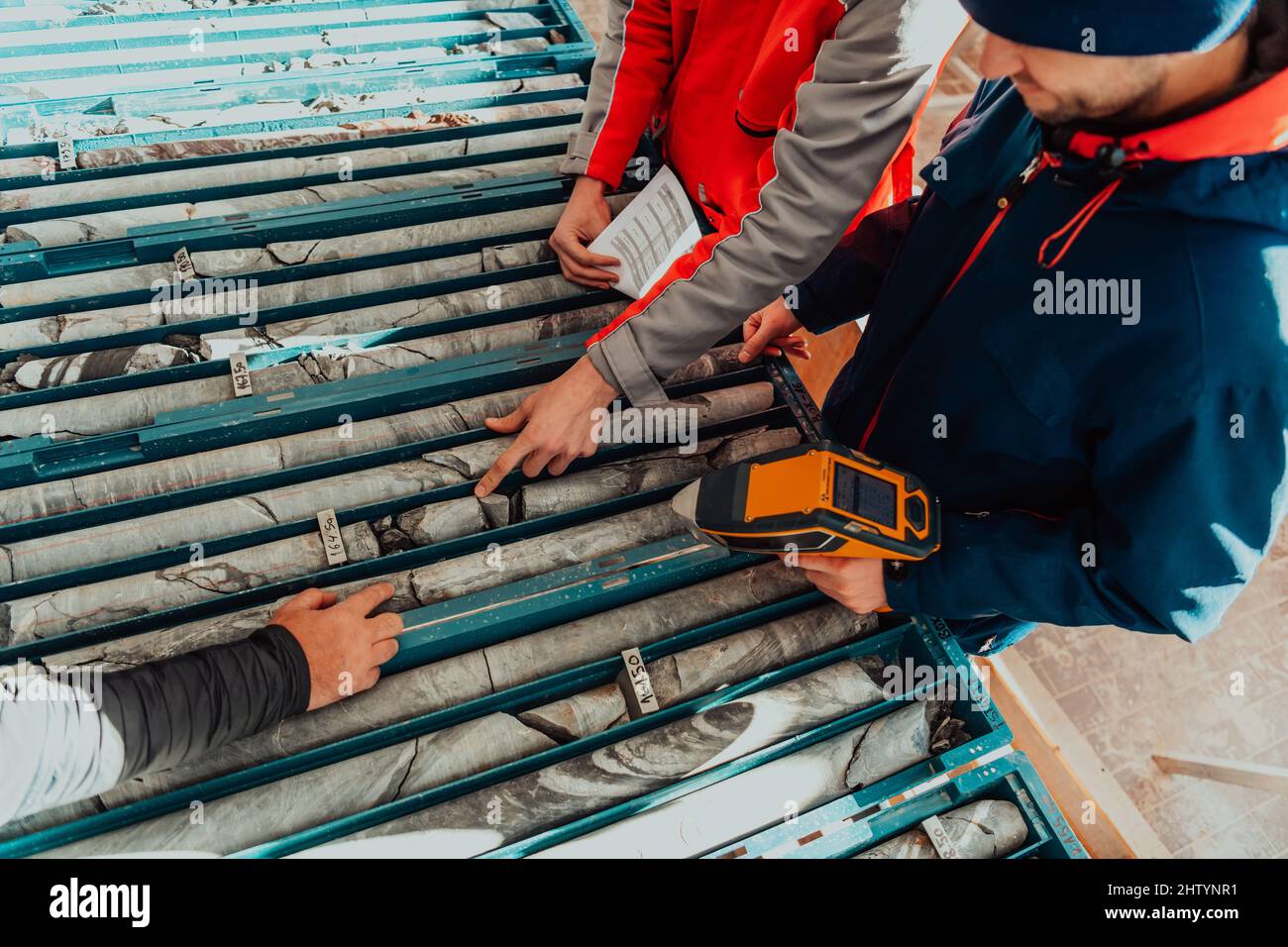 Geological gold core samples with team of mining workers measuring ...