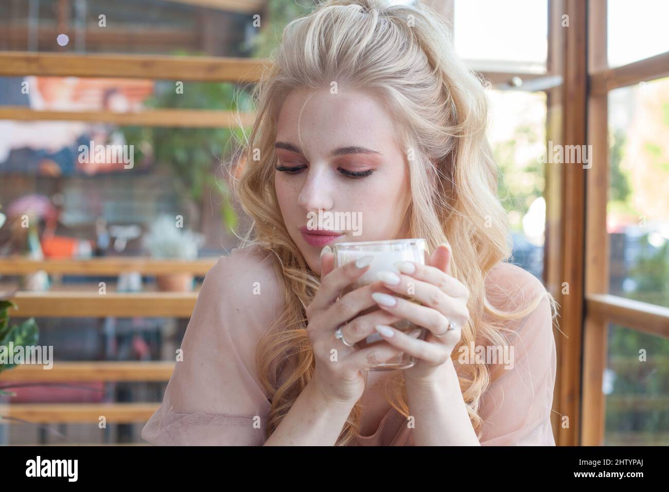 Pretty woman drinking coffee in a cafe Stock Photo - Alamy