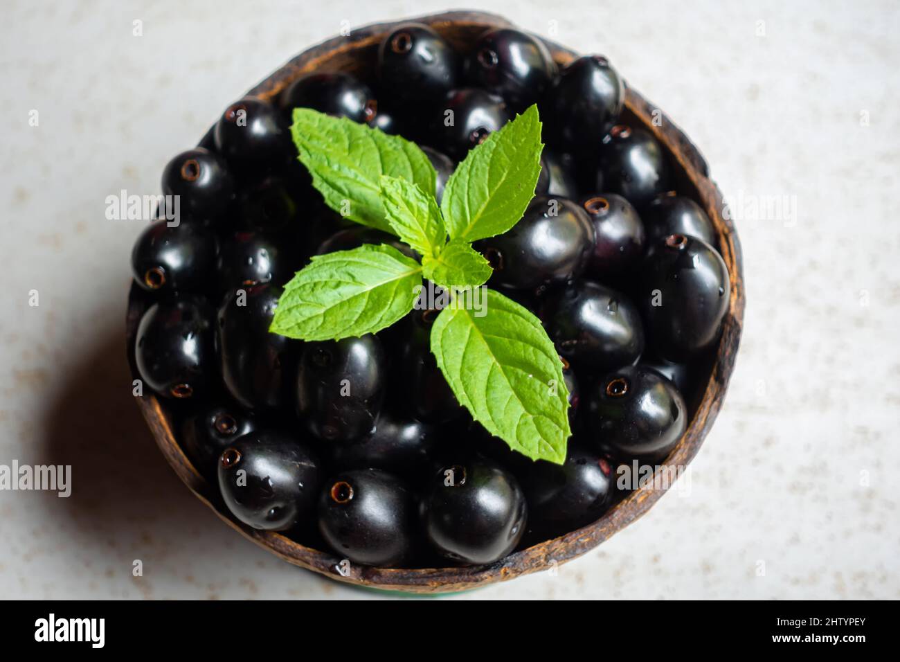 Black ripe Syzygium cumini fruits. Dark black java plum in a wood bowl ...