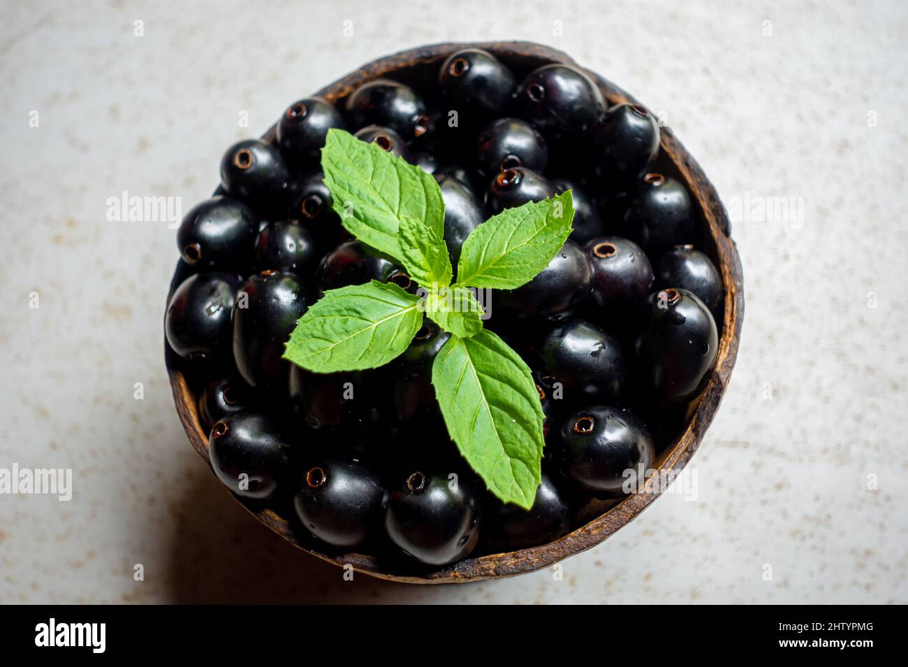 Black ripe Syzygium cumini fruits. Dark black java plum in a wood bowl ...