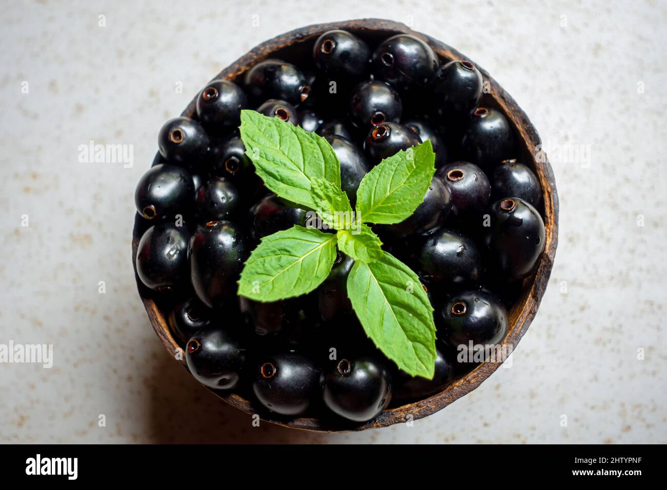 Black ripe Syzygium cumini fruits. Dark black java plum in a wood bowl ...