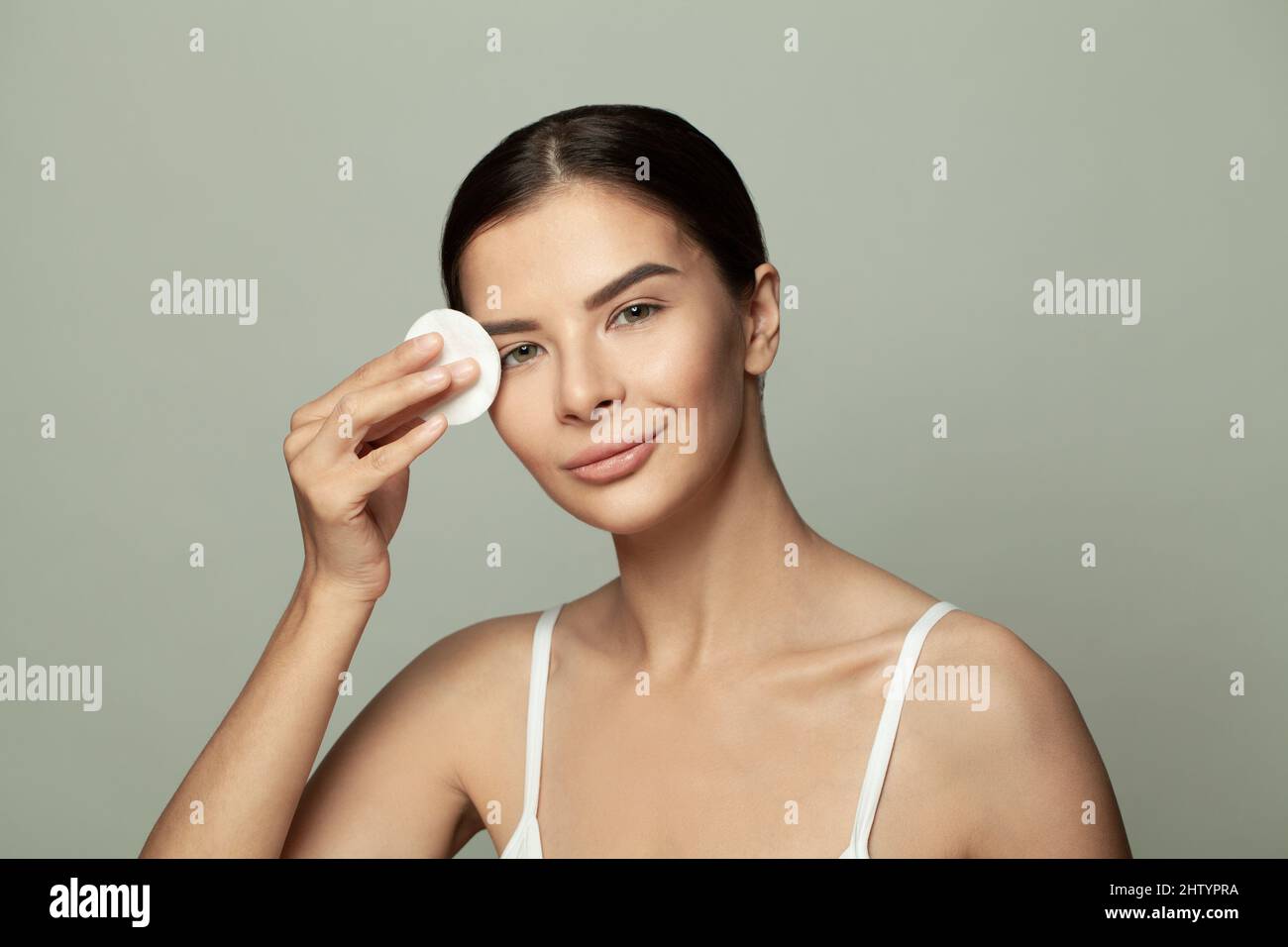 Healthy female model removing makeup with cotton pad and smiling Stock ...
