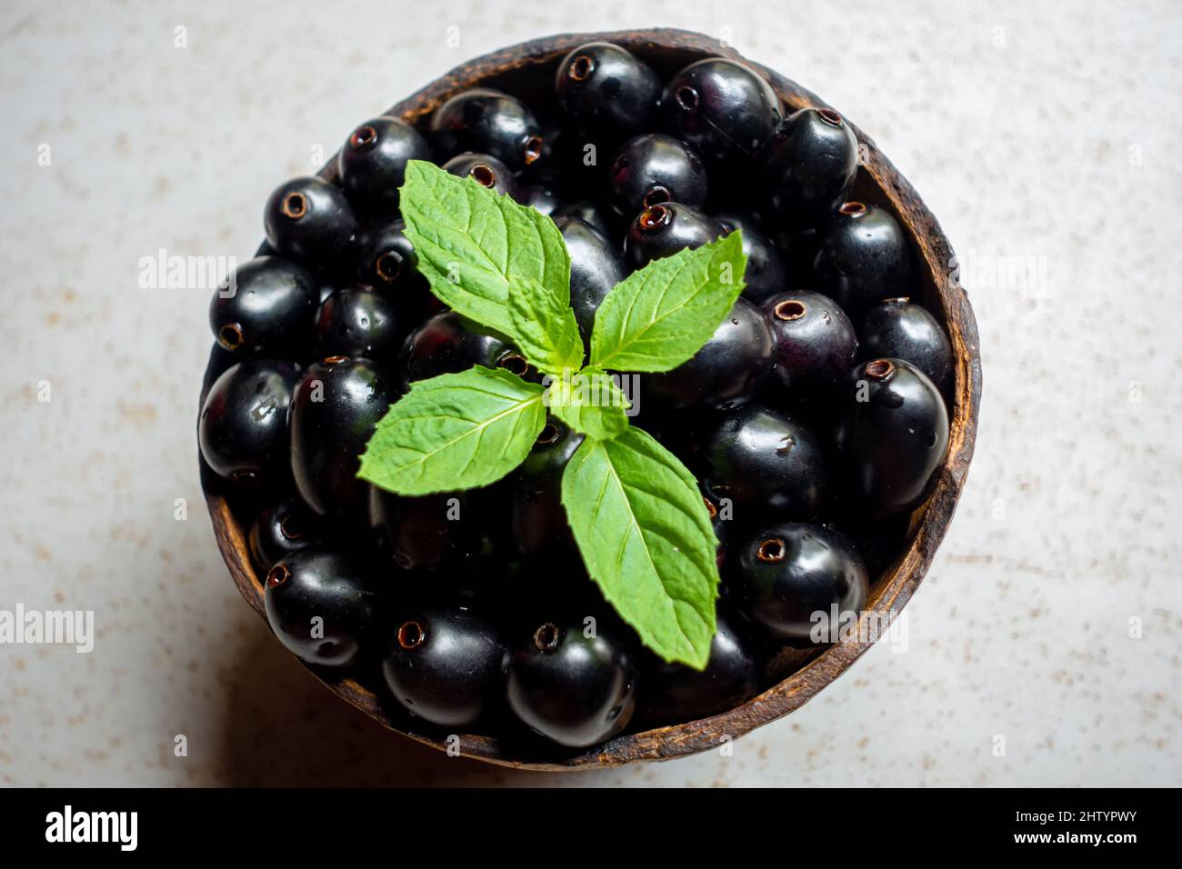Black ripe Syzygium cumini fruits. Dark black java plum in a wood bowl ...