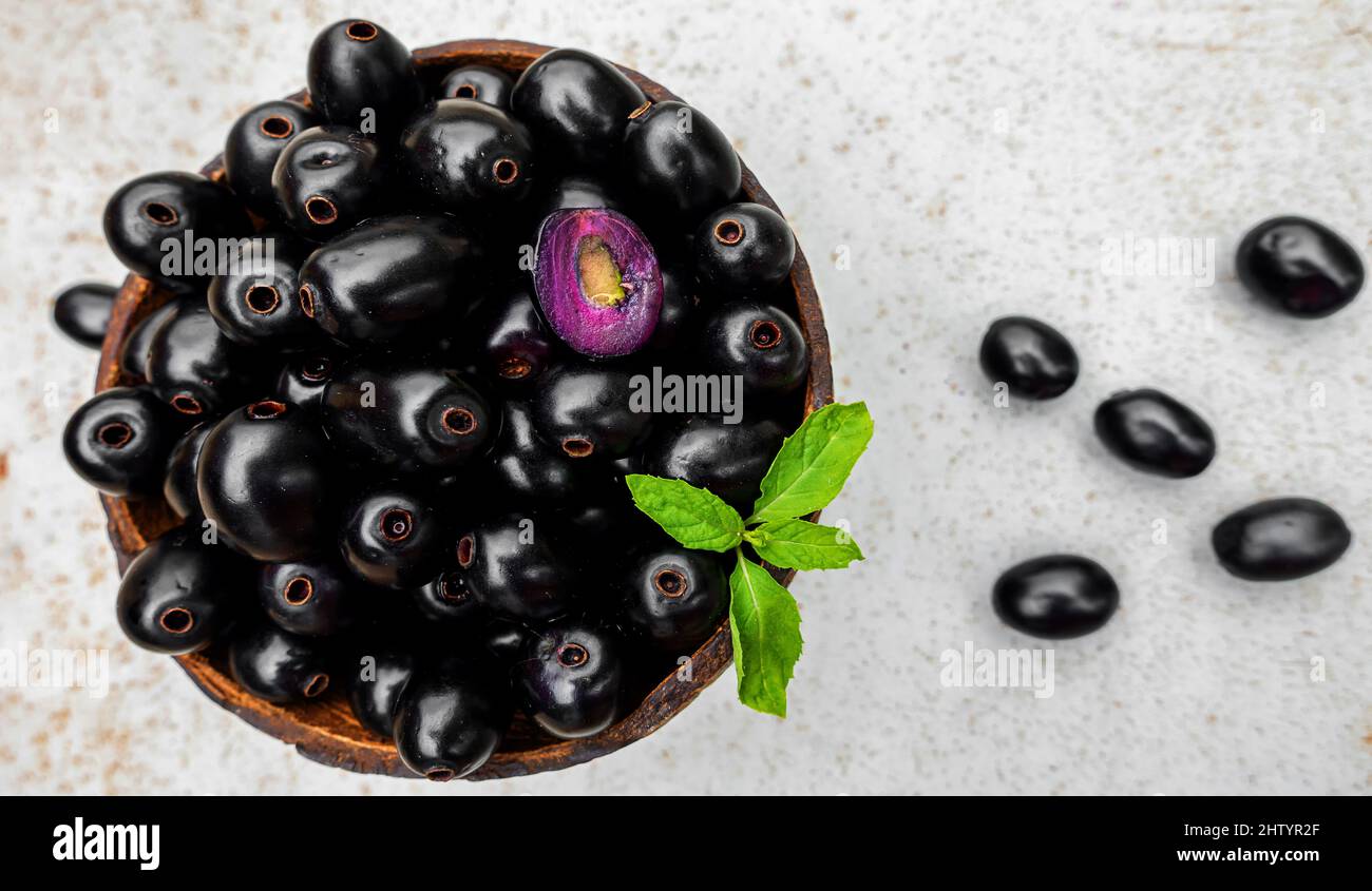 Black ripe Syzygium cumini fruits. Dark black java plum in a wood bowl ...