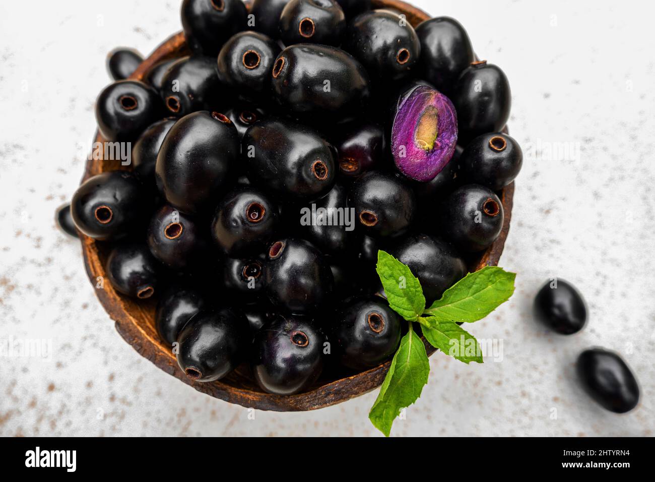 Black ripe Syzygium cumini fruits. Dark black java plum in a wood bowl ...