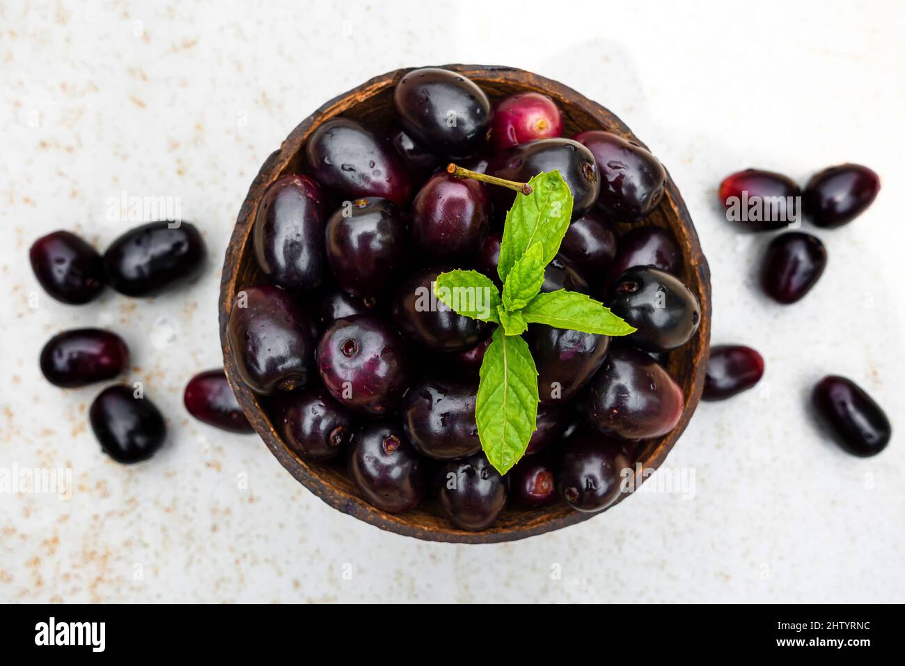 Dark pink-red ripe Syzygium cumini fruits. Dark black java plum in a ...
