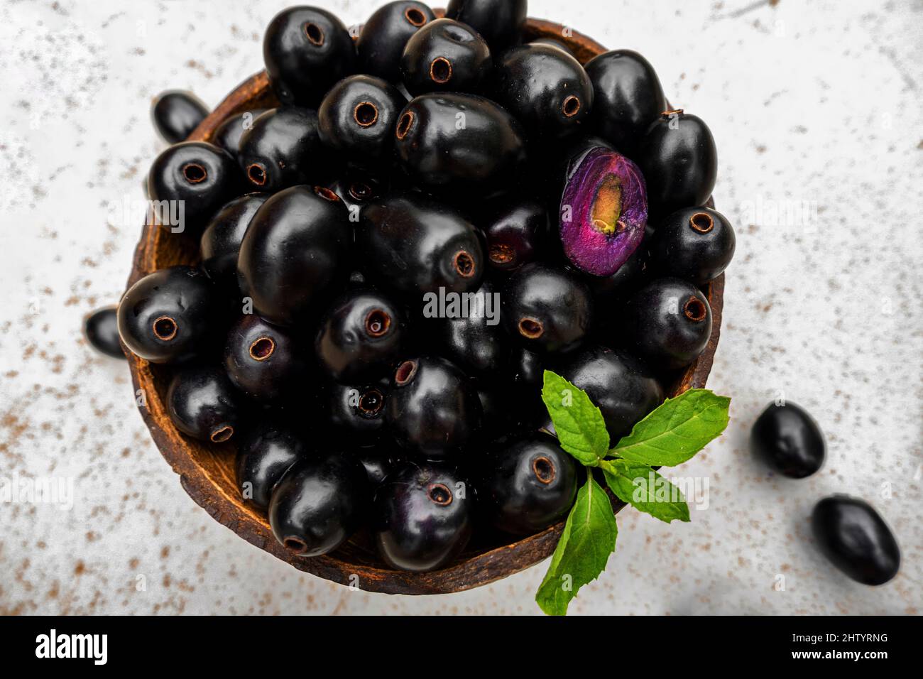 Black ripe Syzygium cumini fruits. Dark black java plum in a wood bowl ...