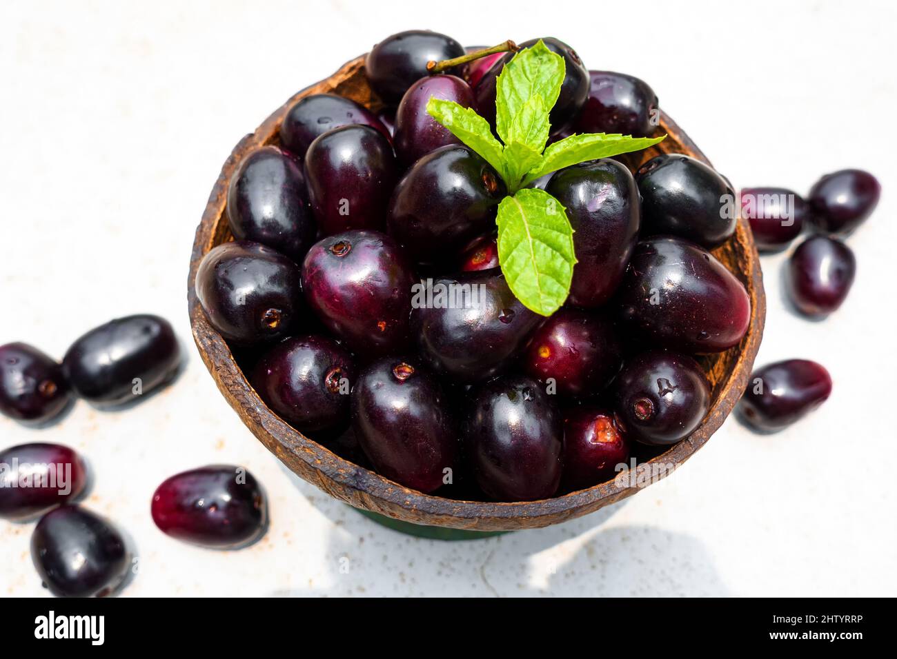 Dark pink-red ripe Syzygium cumini fruits. Dark black java plum in a ...