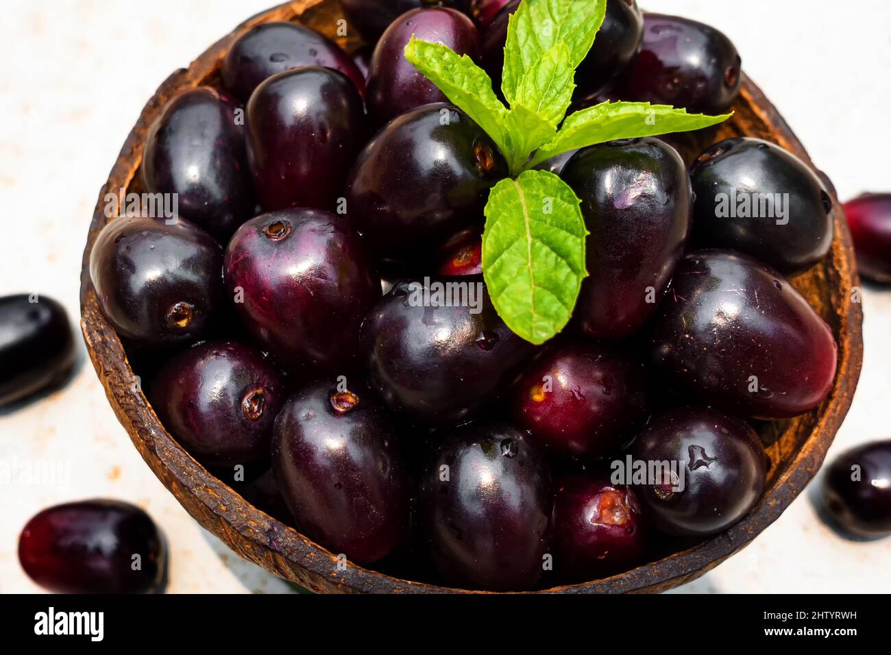 Dark pink-red ripe Syzygium cumini fruits. Dark black java plum in a ...