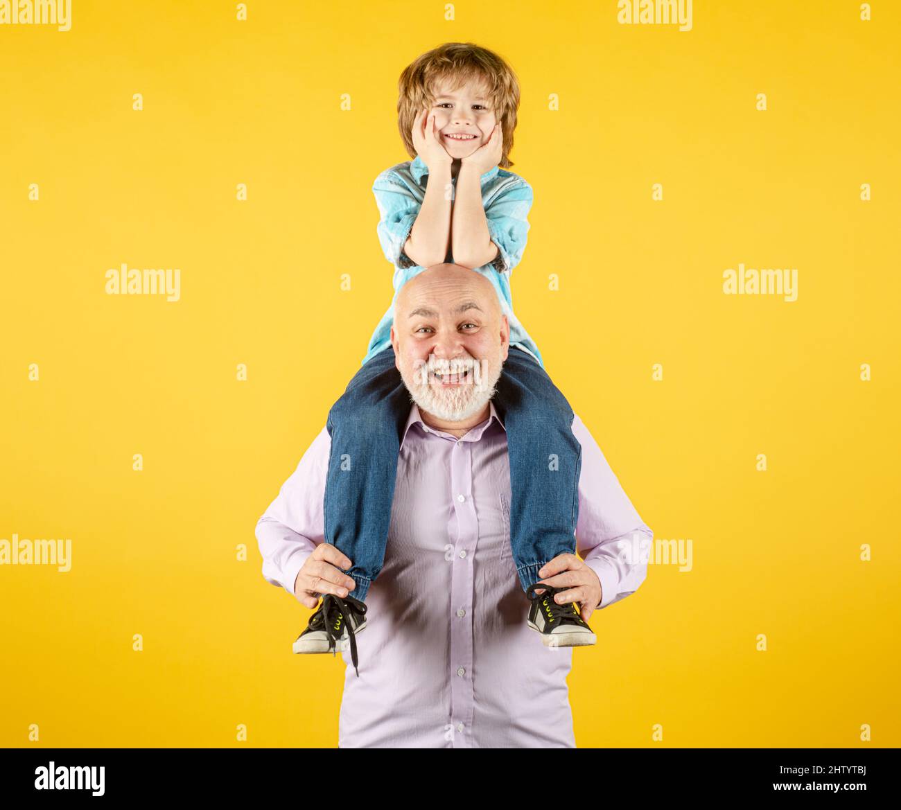 Old grandfather and young child grandson piggyback ride with funny face ...
