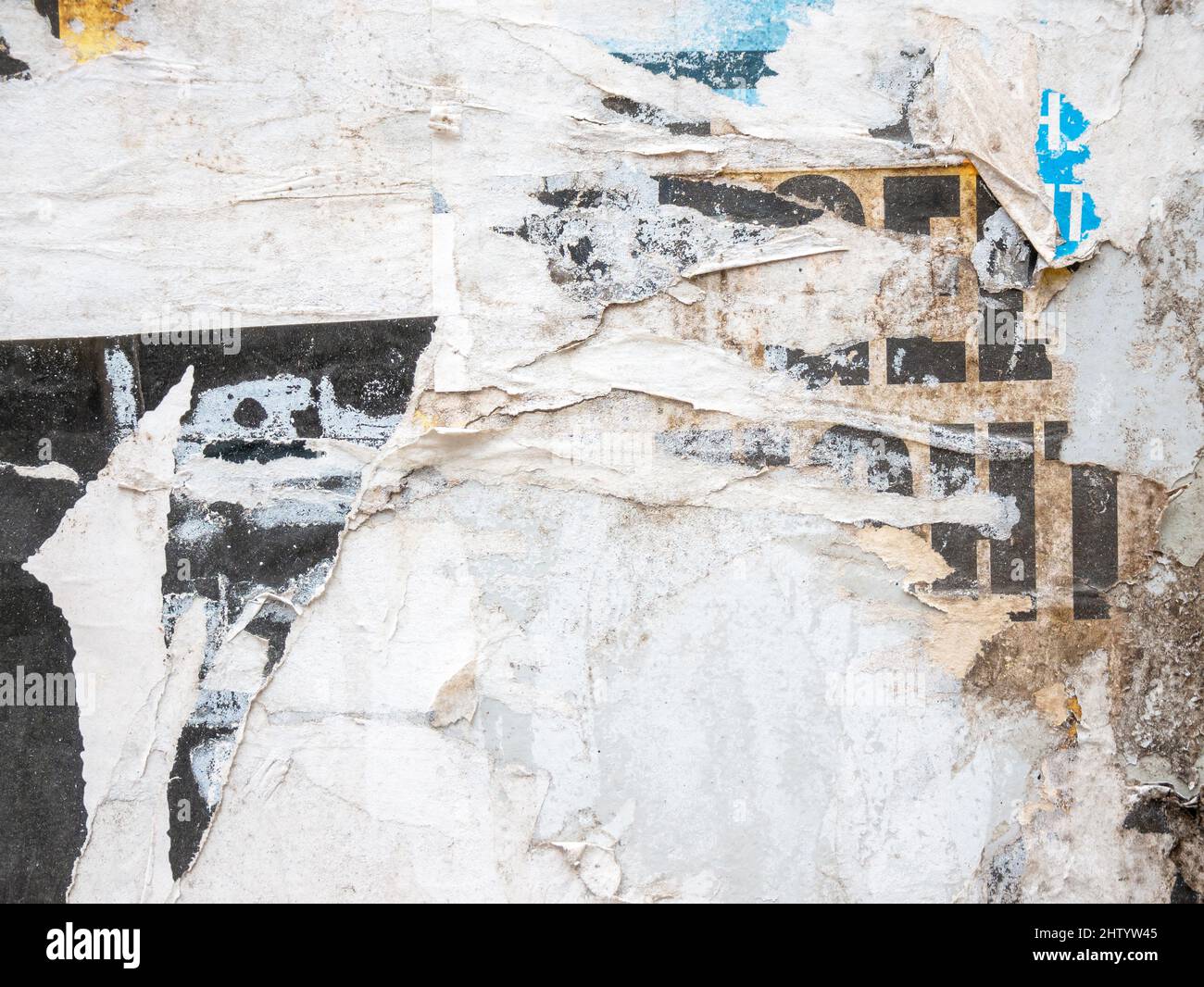 Lots of torn damaged paper posters, adverts, scraped off advertisements ...