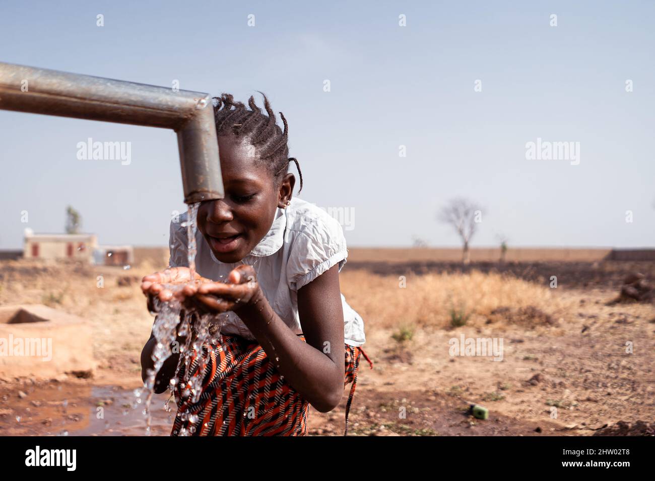 Clean water supply concept: young black African native girl drinking ...