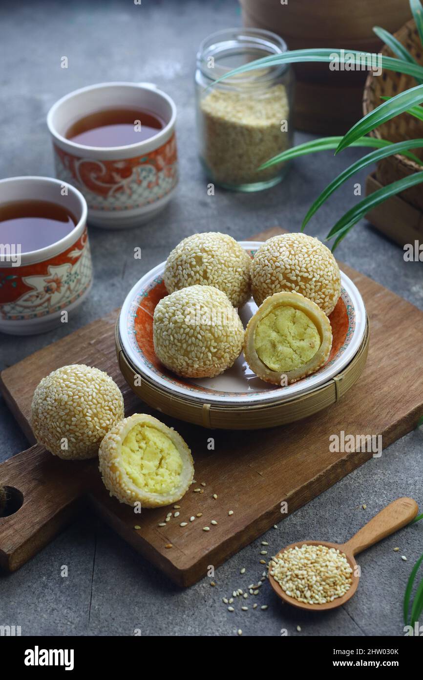Onde Onde or glutinous rice cake sesame ball on ceramic plate with cups ...