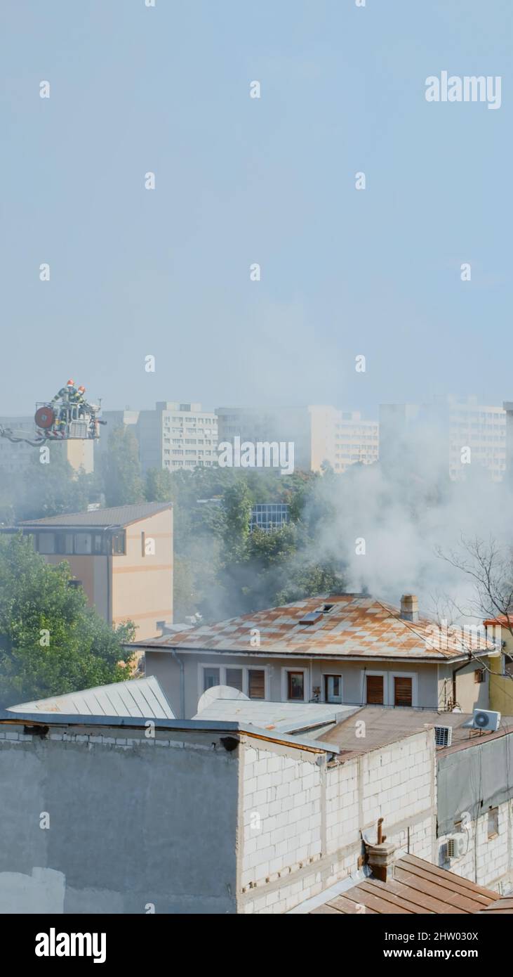View of burning house and firefighters trying to extinguish fire from ...