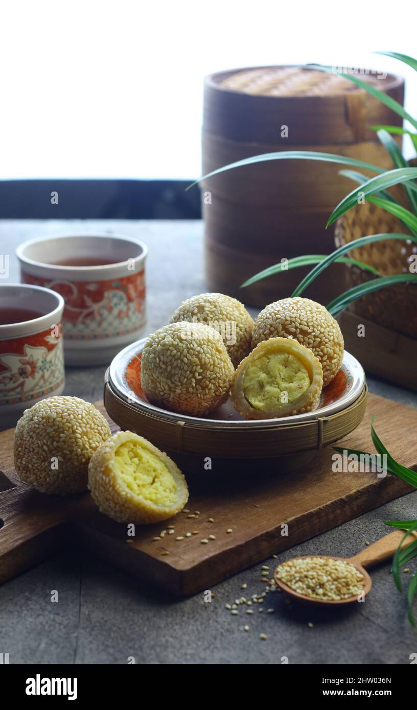 Onde Onde or glutinous rice cake sesame ball on ceramic plate with cups ...