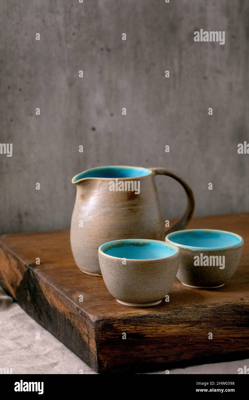 Set of empty turquoise grey textured craft ceramic jug and cups ...