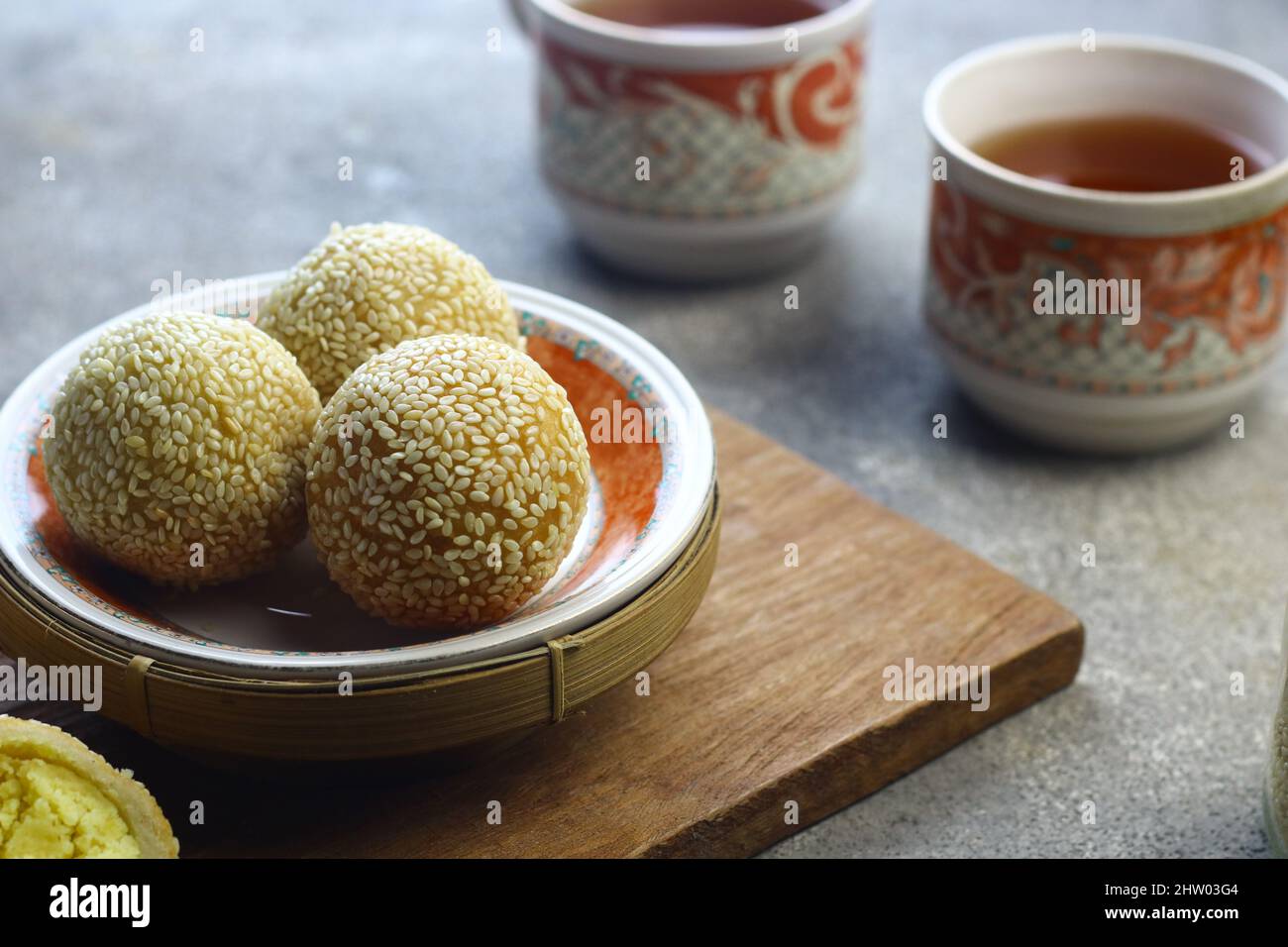 Onde Onde or glutinous rice cake sesame ball on ceramic plate with cups ...