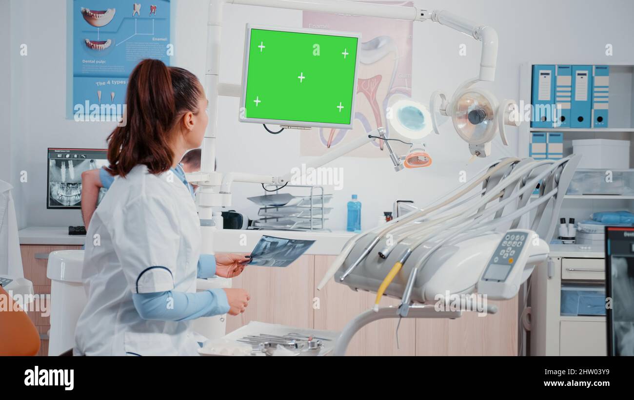 Dentist receiving teeth scan from man while looking at green screen on ...