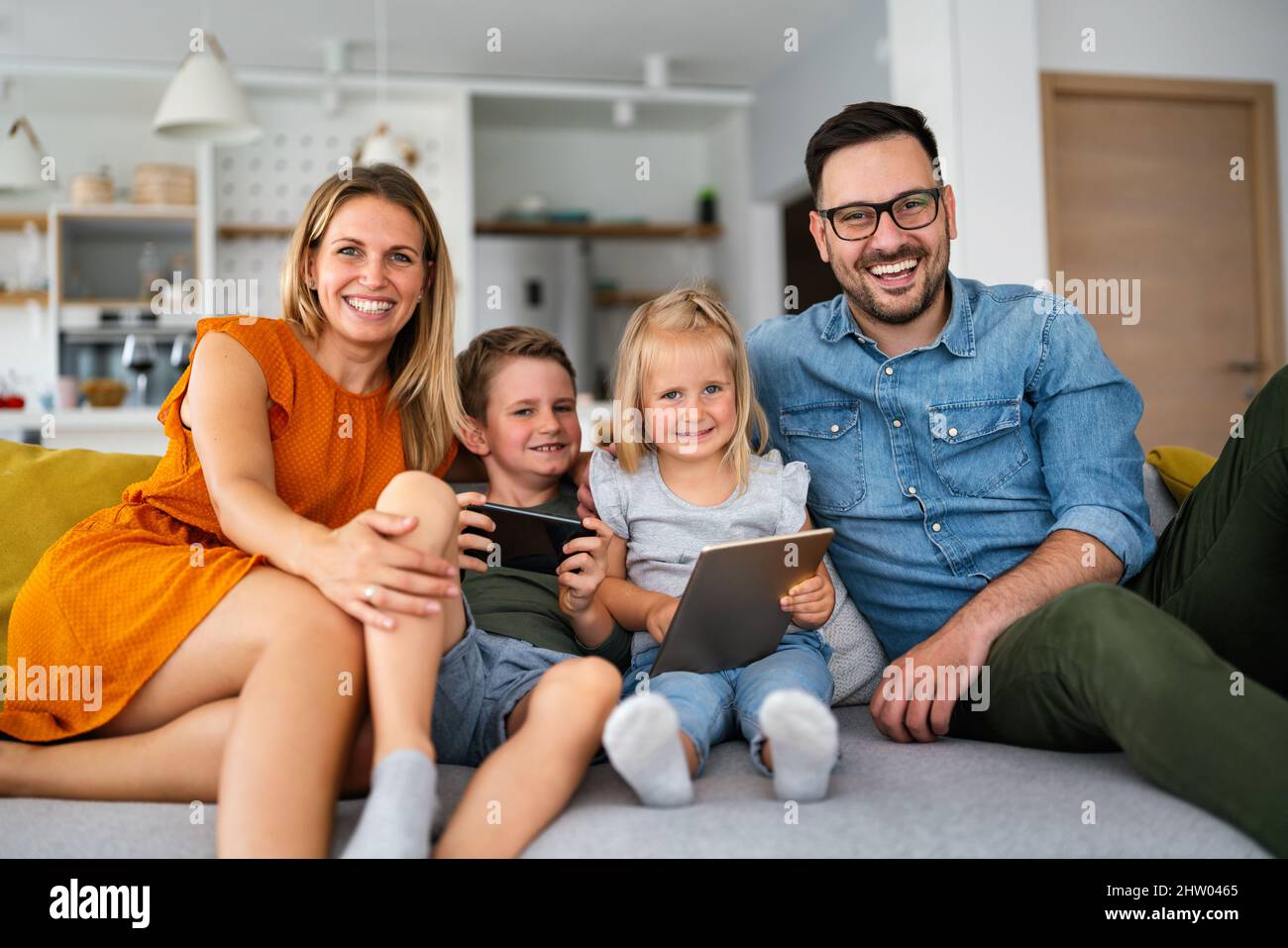 Happy family spending time at home with digital devices together ...