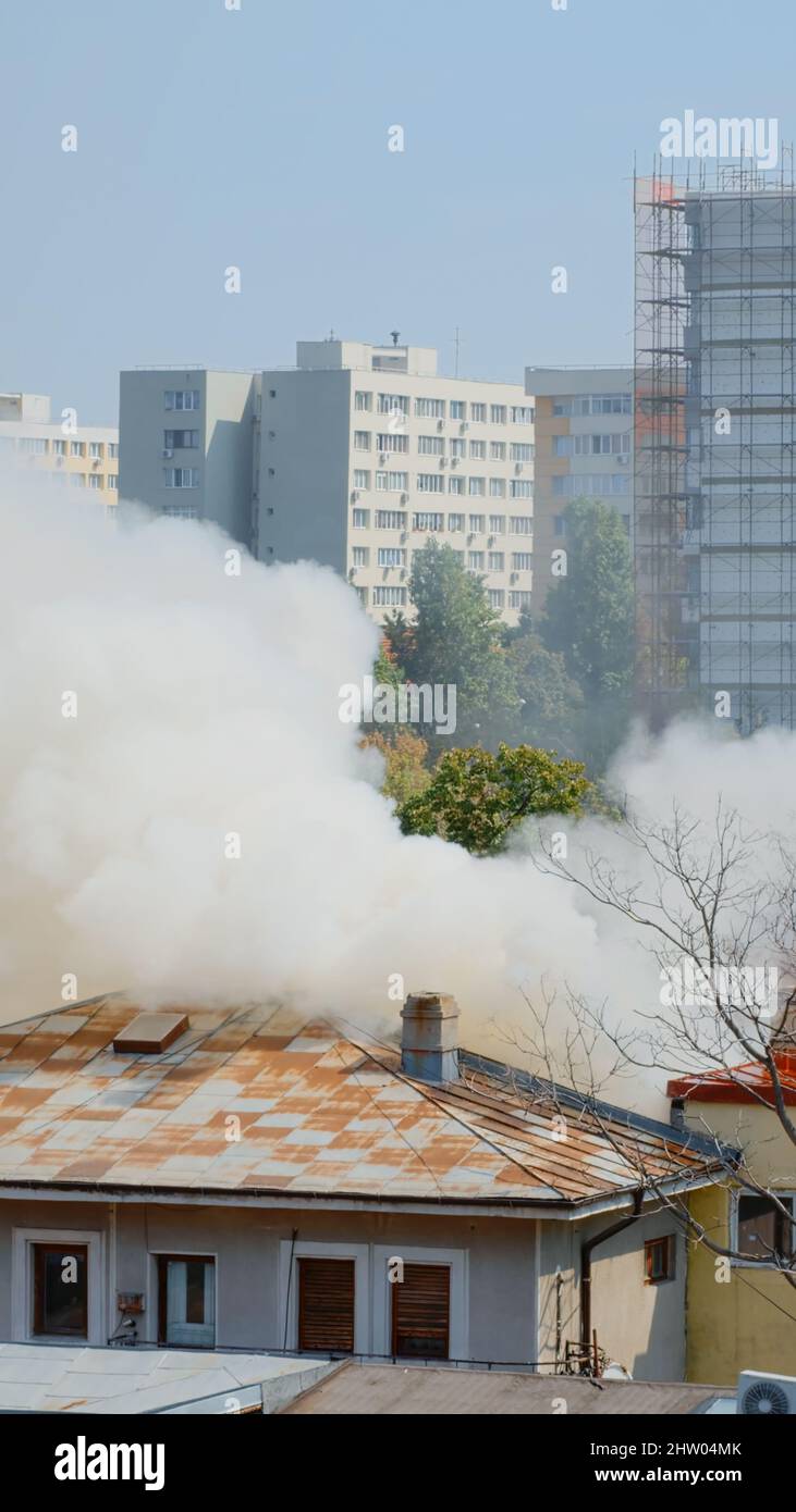 View of firefighters using water to extinguish fire from burning house ...