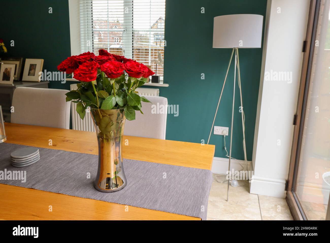 Bunch of one dozen red roses on a modern dining table Stock Photo - Alamy