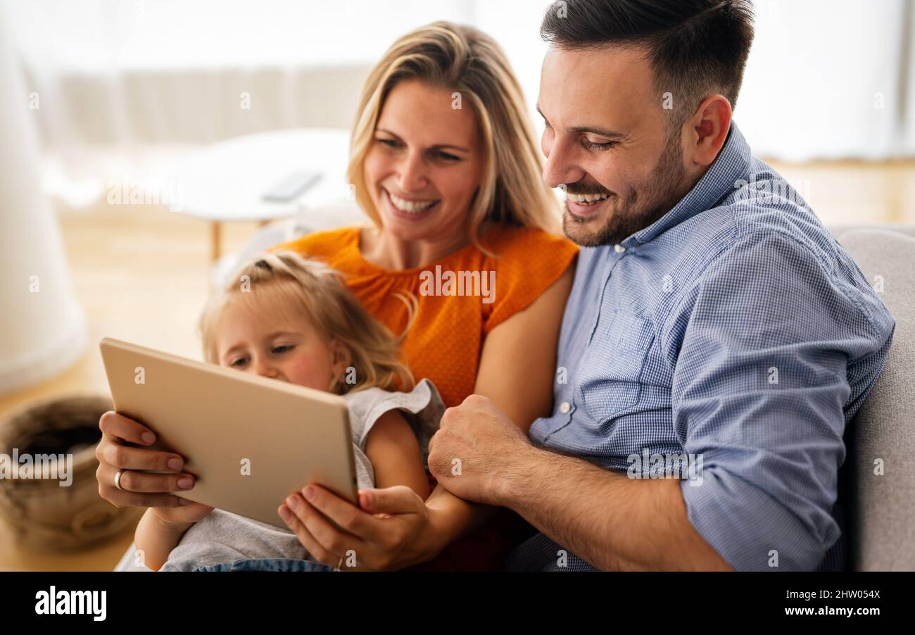 Happy family spending time at home with digital devices together ...