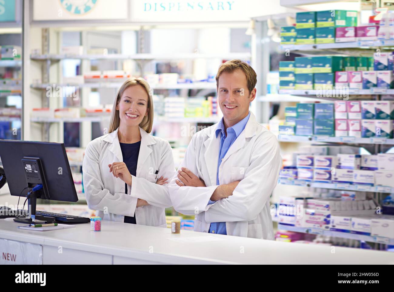Filling prescriptions and customers needs. Portrait of two pharmacists ...