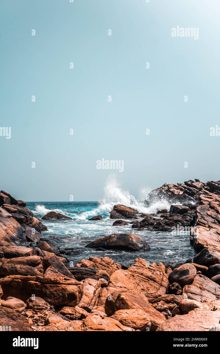 Vertical shot of a rocky beach under the clear skies Stock Photo - Alamy