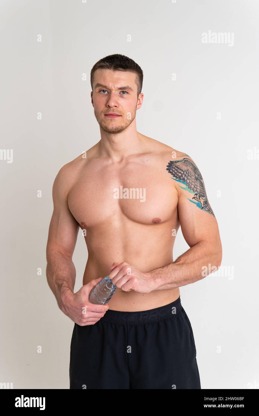 Male drink-water fitness is pumped with a towel on a white background ...