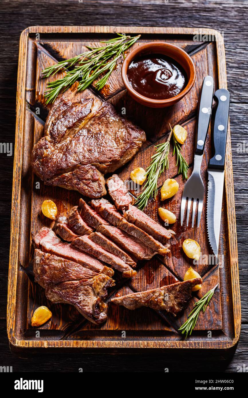 fried juicy chuck eye beef steaks, a whole and one cut in slices with ...