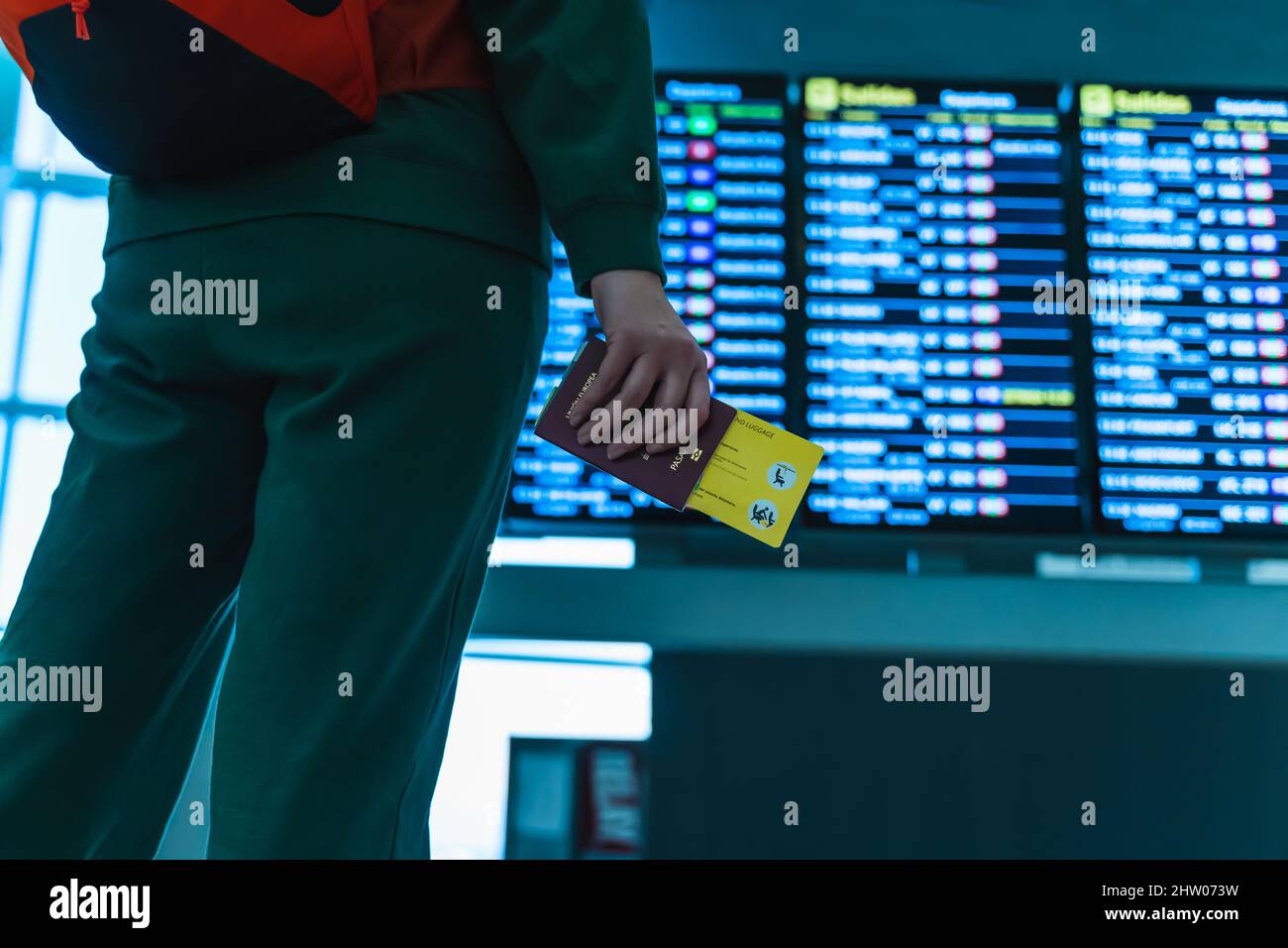 woman at the airport looking at the screens for her flight Stock Photo ...