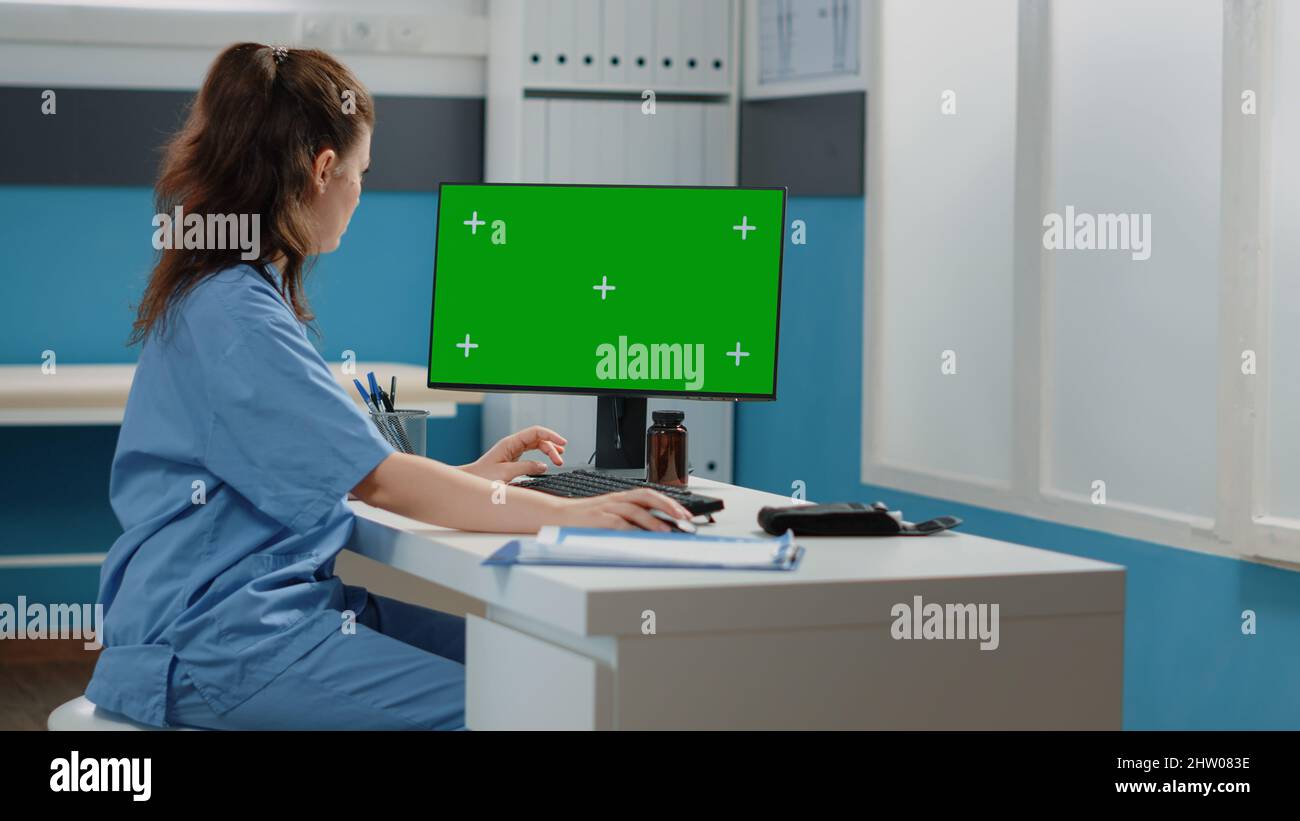 Woman working as nurse with green screen on computer. Healthcare ...