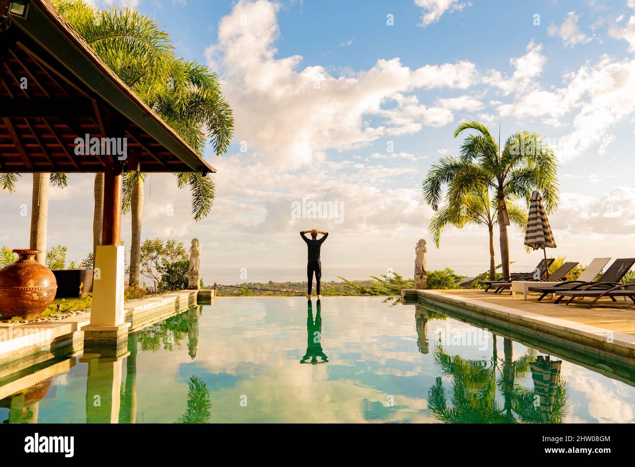 A man standing at the edge of infinity pool Stock Photo - Alamy