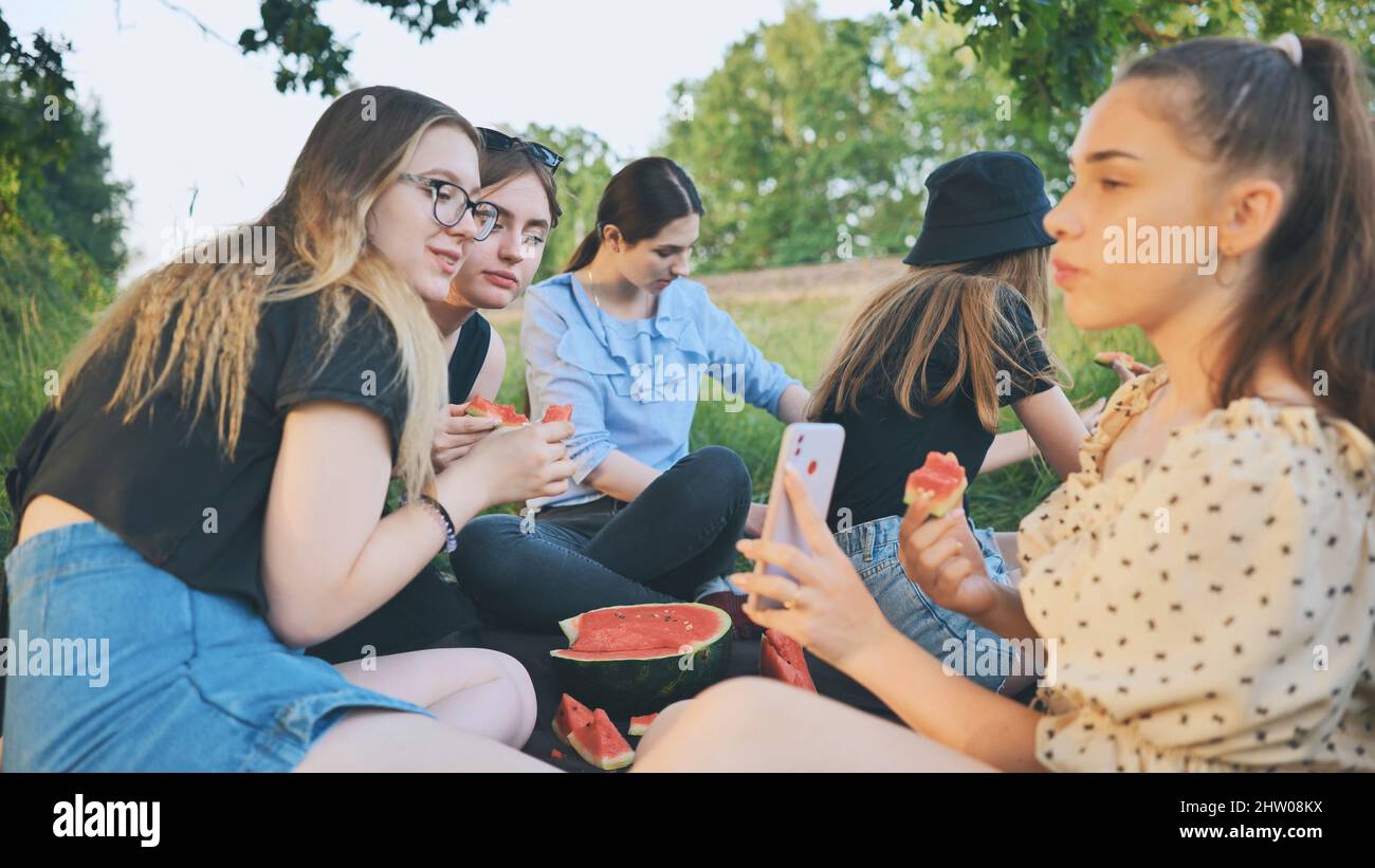 Friends have fun eating watermelon outside the city at a picnic Stock ...