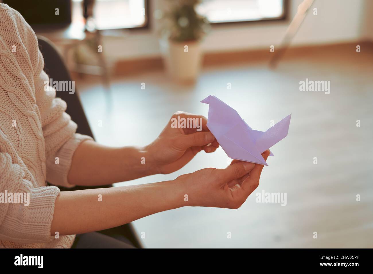 Origrami folded bird in woman's hands during a masterclass Stock Photo ...