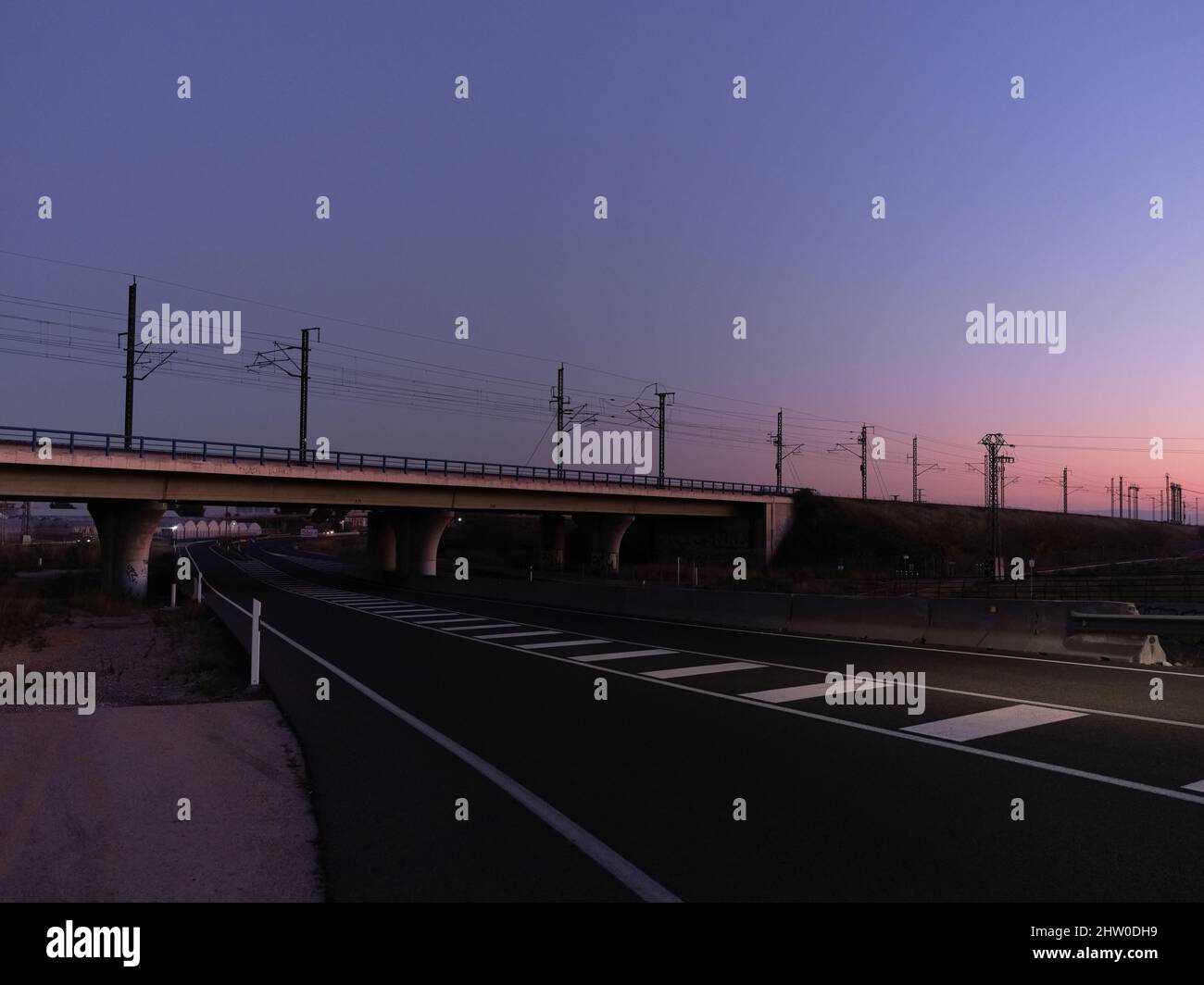 Railway bridge crossing a motorway at sunset Stock Photo - Alamy