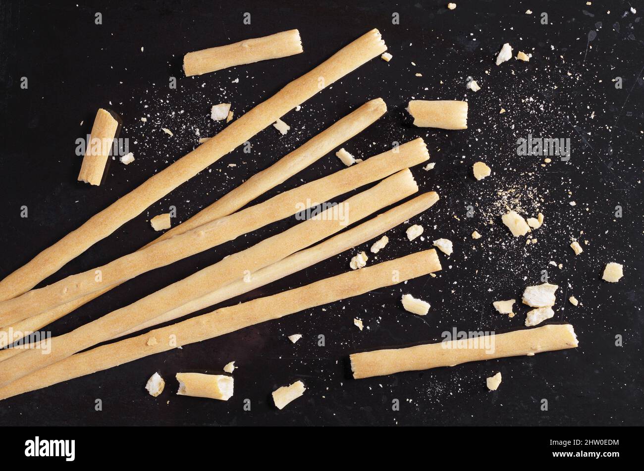 Bread sticks whole and broken on old black metal background, top view ...