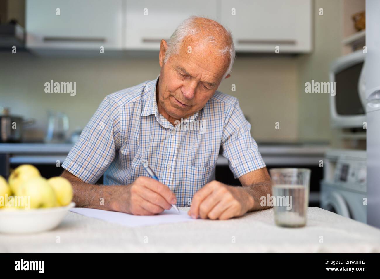 The old man is writing a letter on the table Stock Photo - Alamy