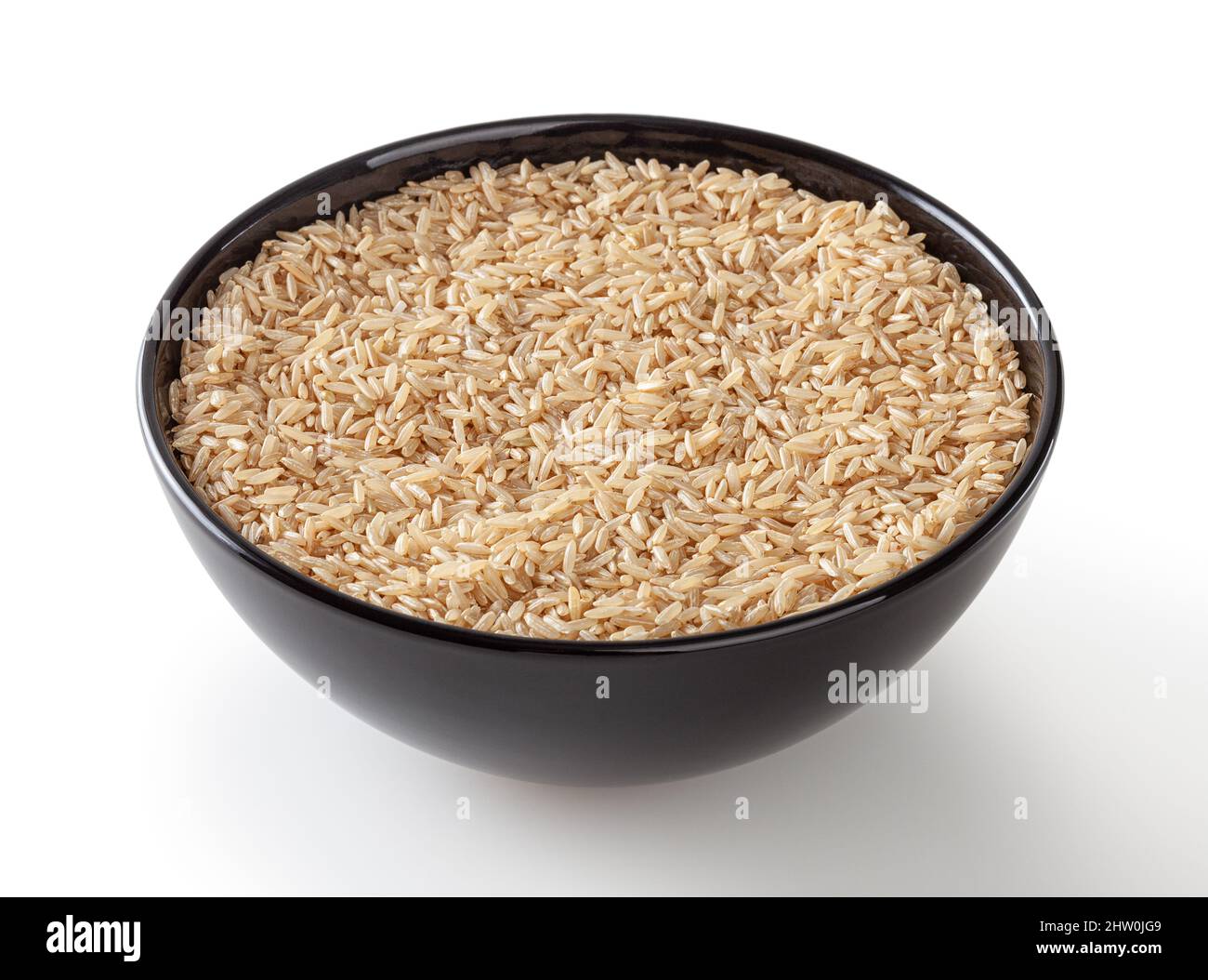 Brown rice in black bowl isolated on white background with clipping ...