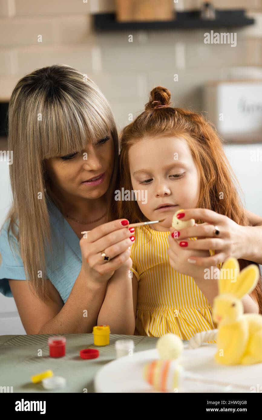 Mom helps her daughter paint Easter eggs Stock Photo - Alamy