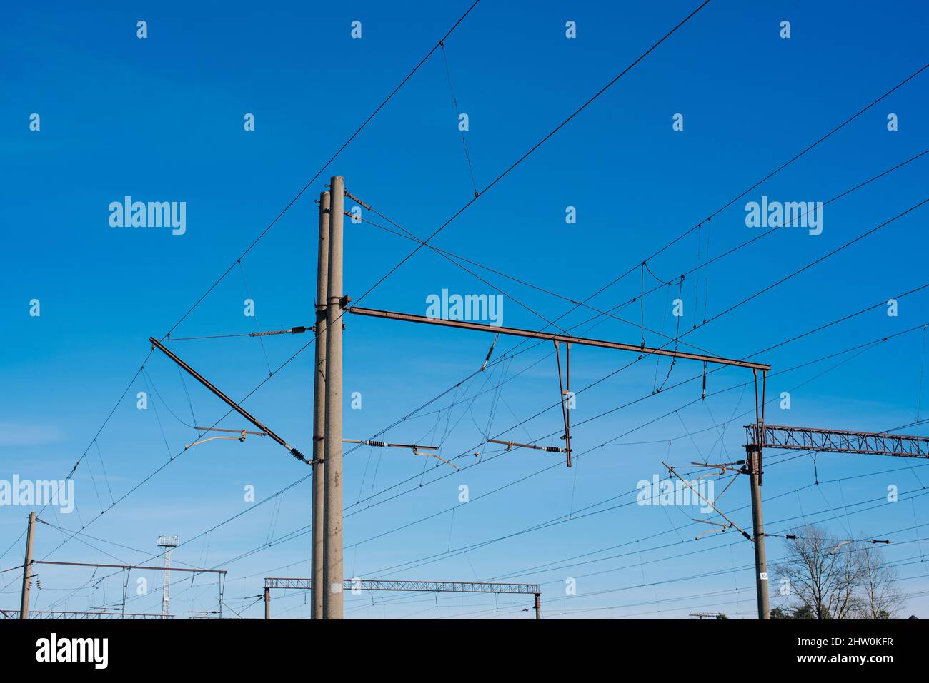Overhead railway power lines and holding structures under blue sky ...