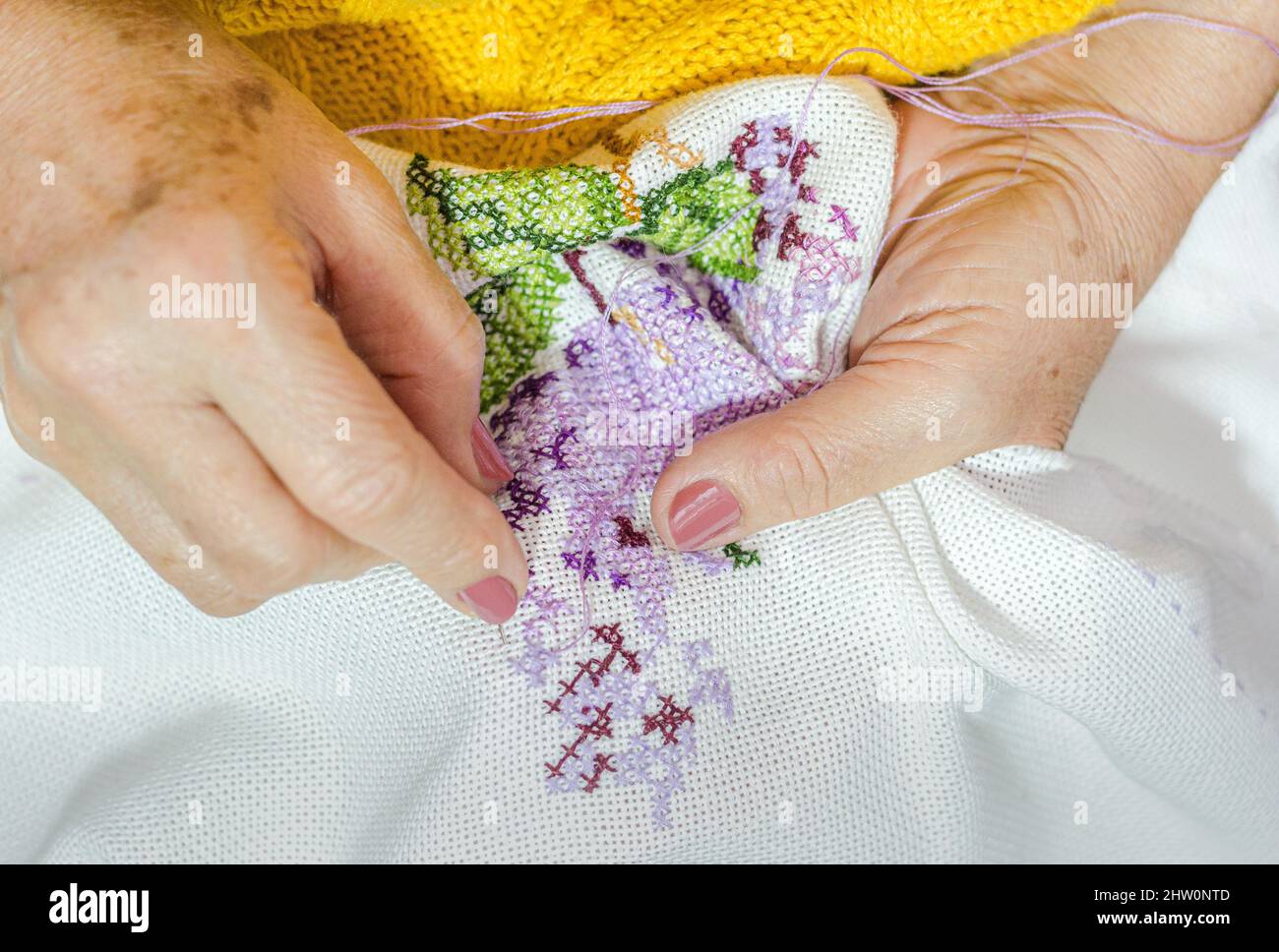 Older adult woman embroidering Stock Photo - Alamy
