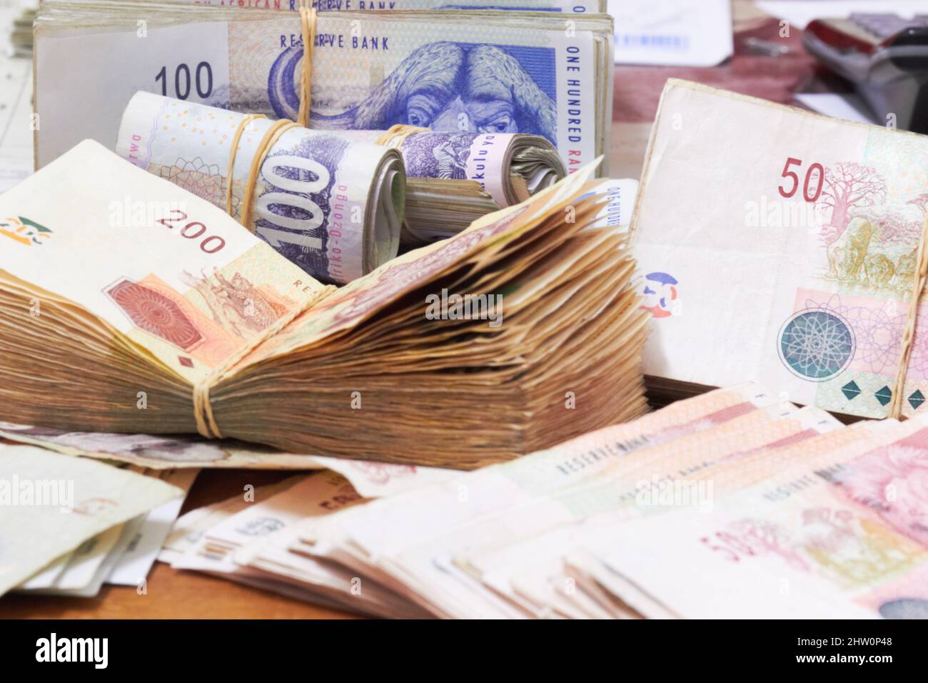 The monthly profit. Large piles of money and loose bills on the table ...