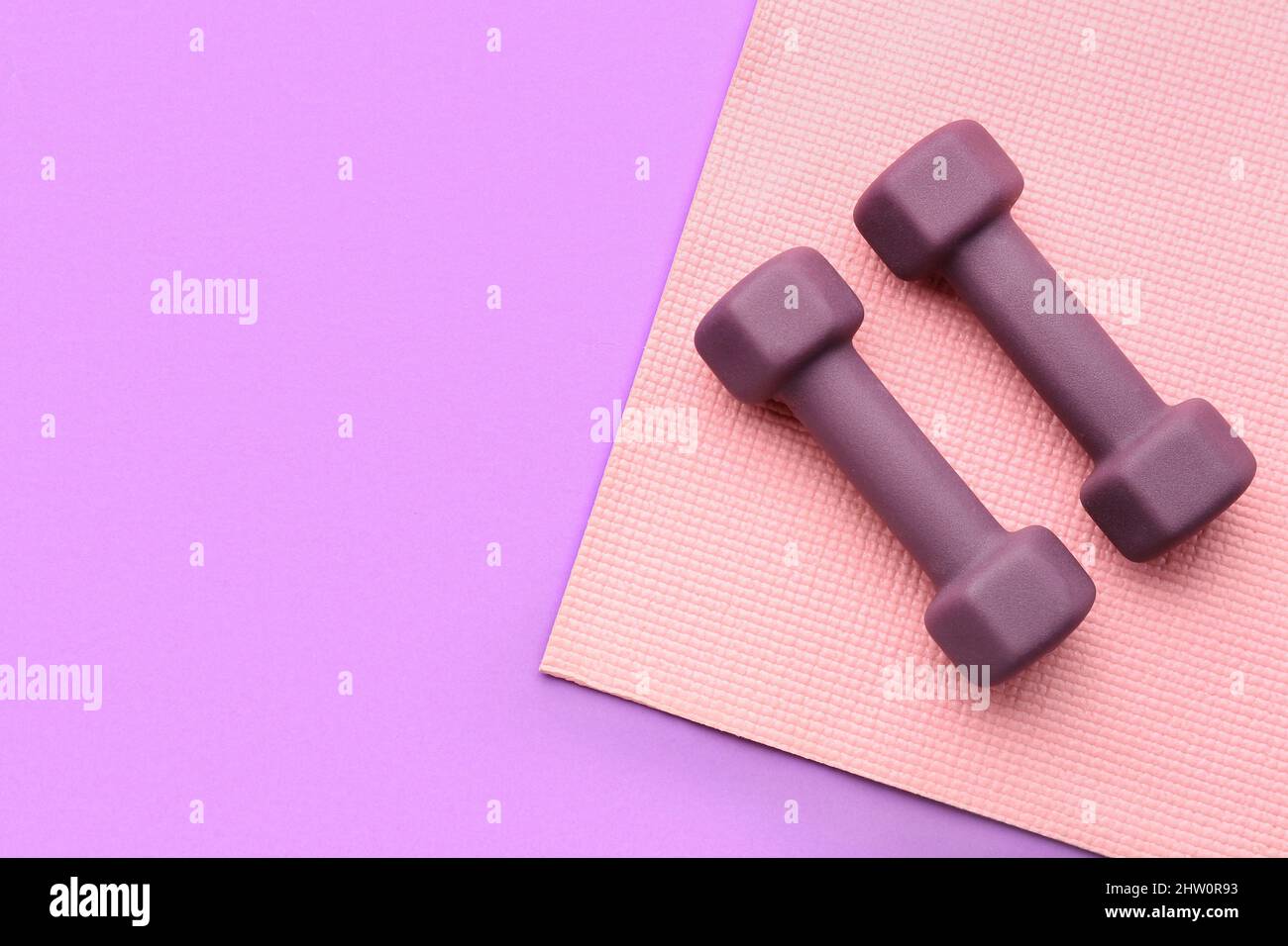 Stylish dumbbells on purple background Stock Photo - Alamy