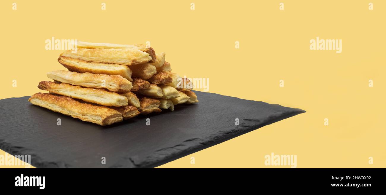 Delicious and sweet puff pastry sticks with cinnamon. Background with ...
